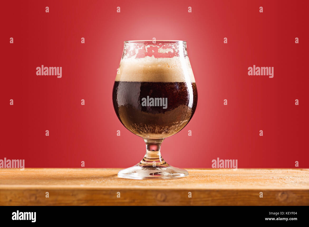 glass of cold frothy dark beer on an old wooden table Stock Photo - Alamy