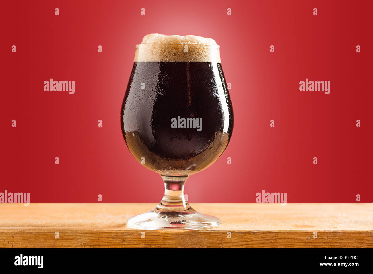 glass of cold frothy dark beer on an old wooden table Stock Photo - Alamy