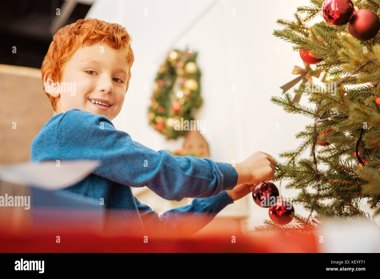 Smiling little child decorating tree for christmas Stock Photo - Alamy