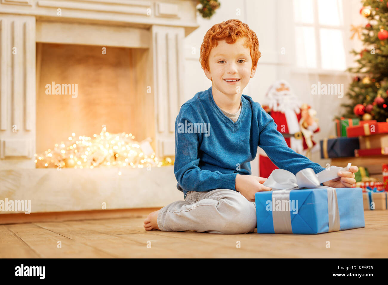 Excited child getting ready to open christmas present Stock Photo - Alamy