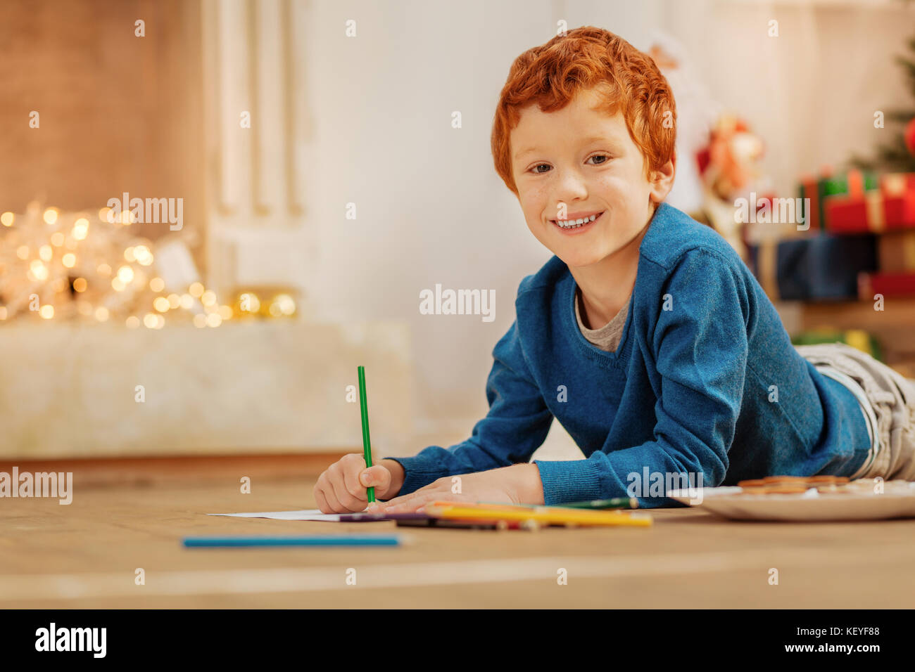 Cheerful kid drawing and smiling into camera Stock Photo - Alamy