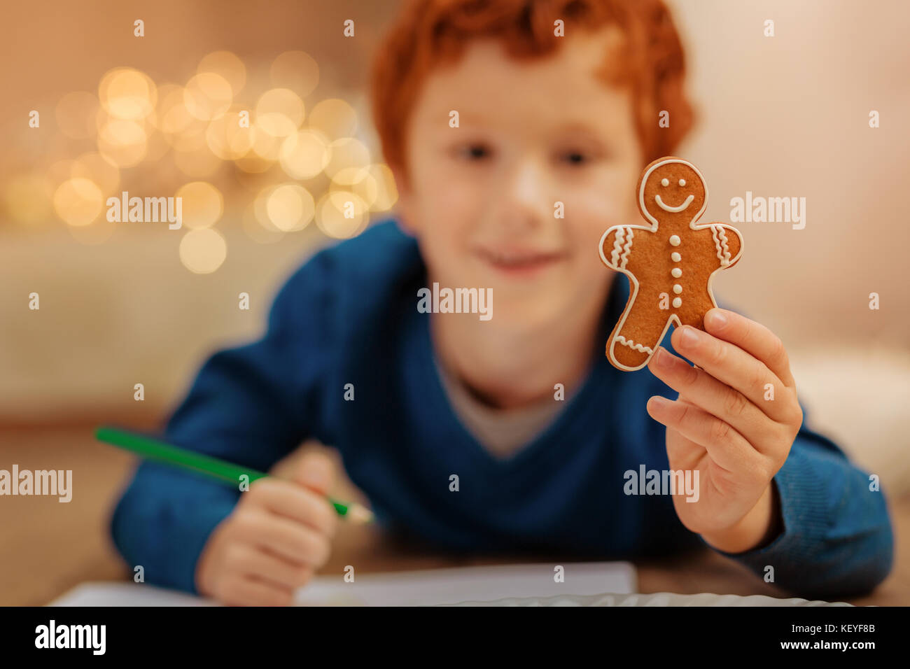 Redhead little boy showing gingerbread man into camera Stock Photo - Alamy