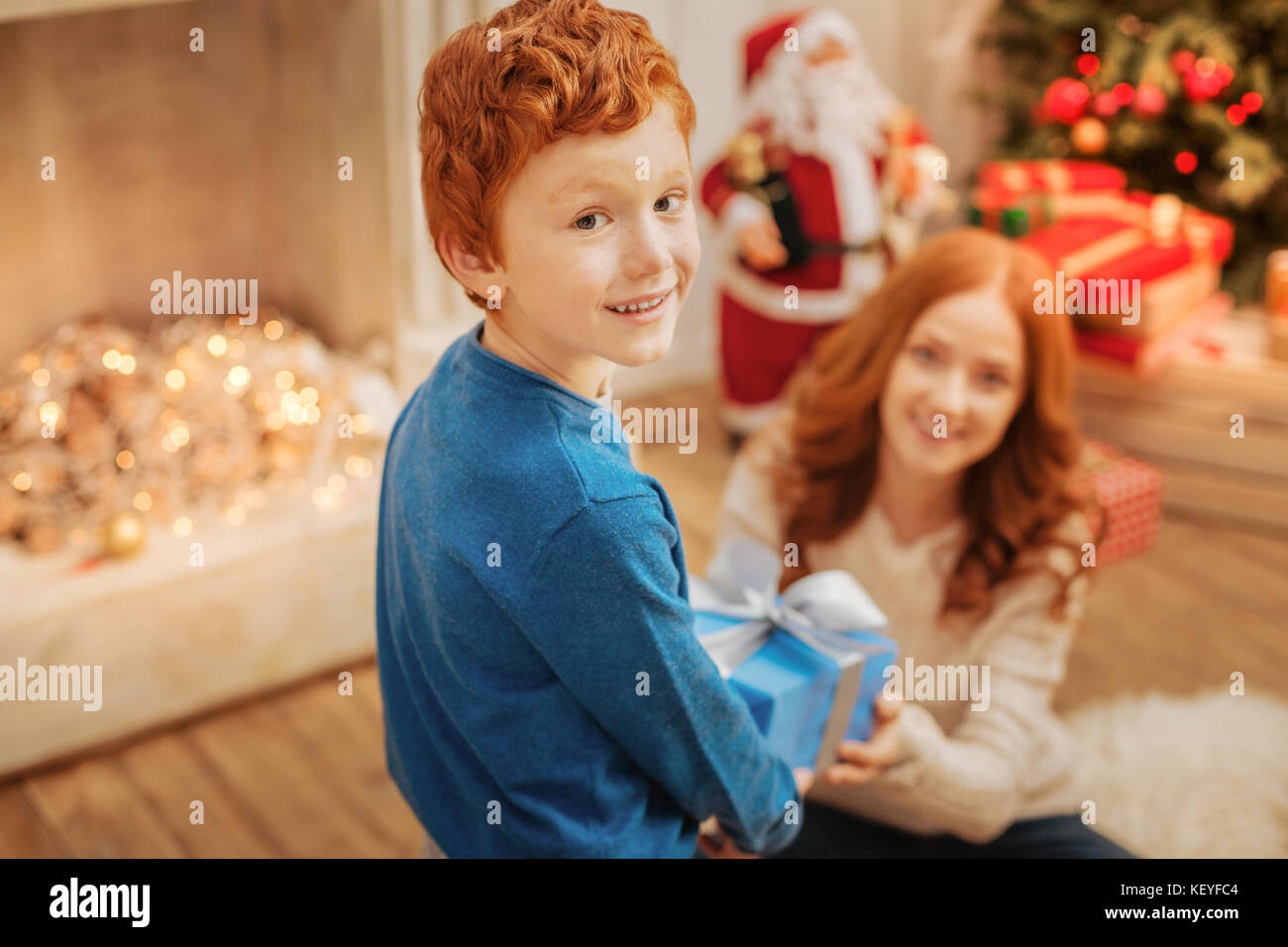 Adorable kid giving his mother christmas present Stock Photo - Alamy