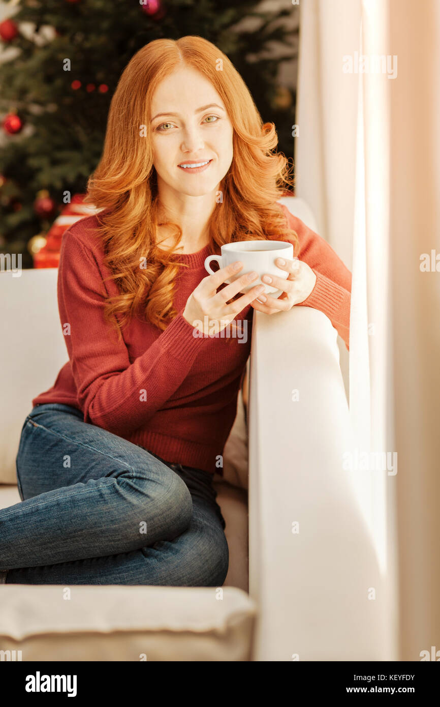 Charming woman smiling while drinking aromatic tea Stock Photo - Alamy