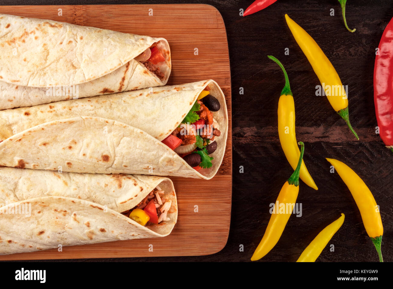 Mexican burritos with chili peppers on dark textures Stock Photo - Alamy