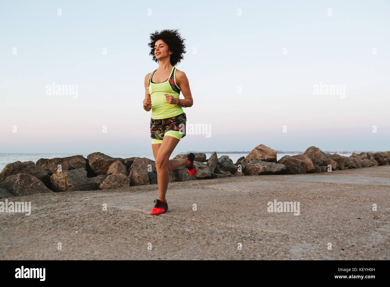 Young fitness woman running outdoors at the beach Stock Photo - Alamy