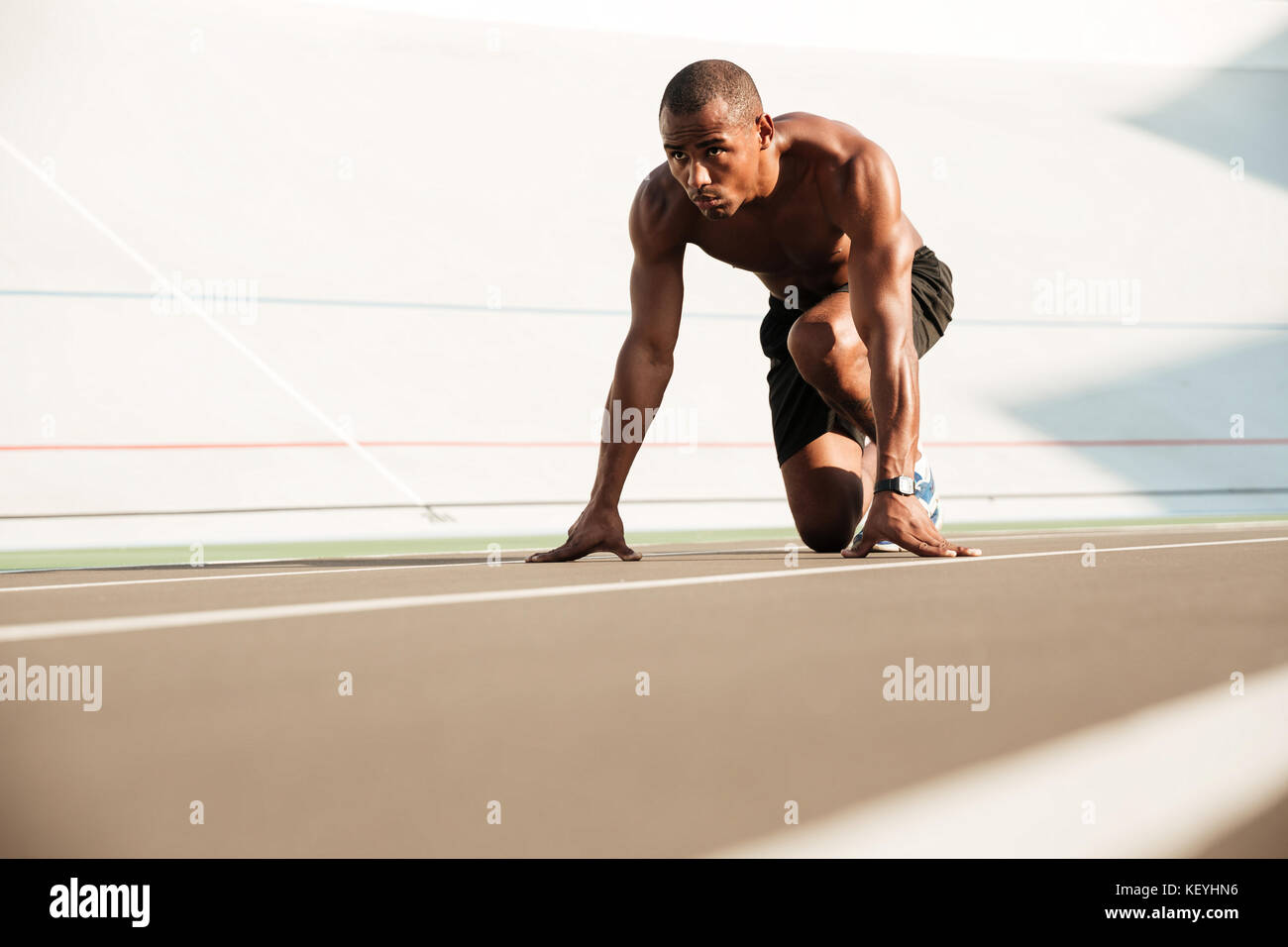 Young african runner starting and preparing to run on the competition ...