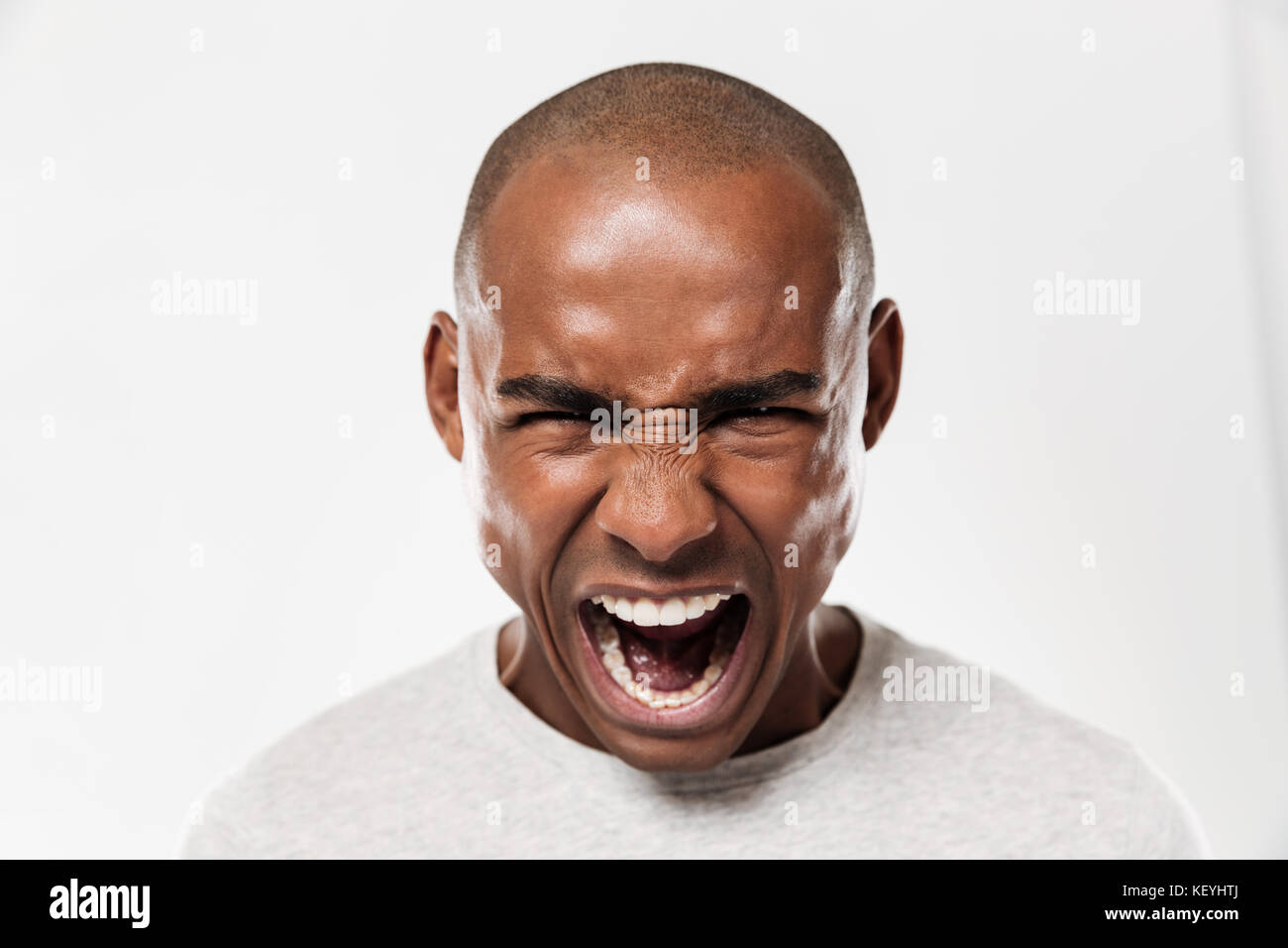 Photo of emotional screaming young african man standing isolated over ...