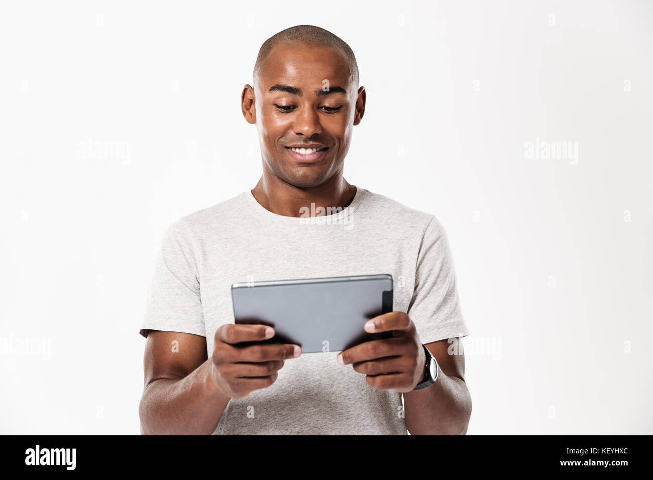 Smiling african man using tablet computer over white background Stock ...