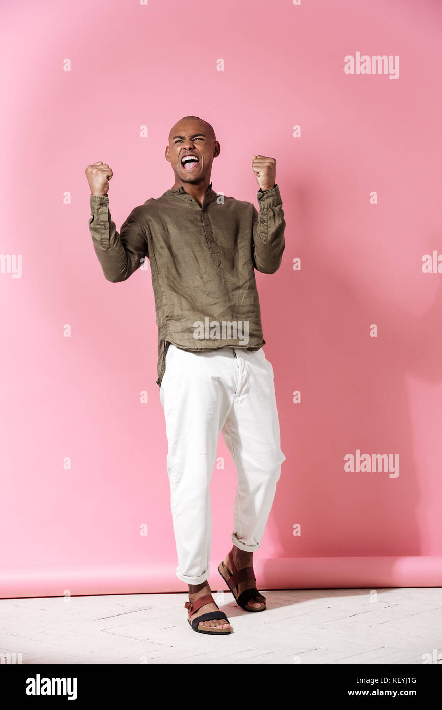 Full length image of happy screaming african man over pink background ...