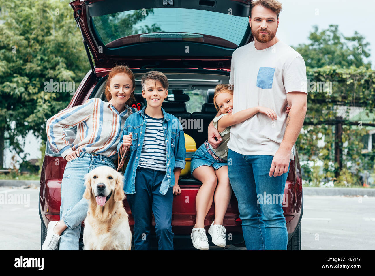 family with dog standing next to car Stock Photo - Alamy