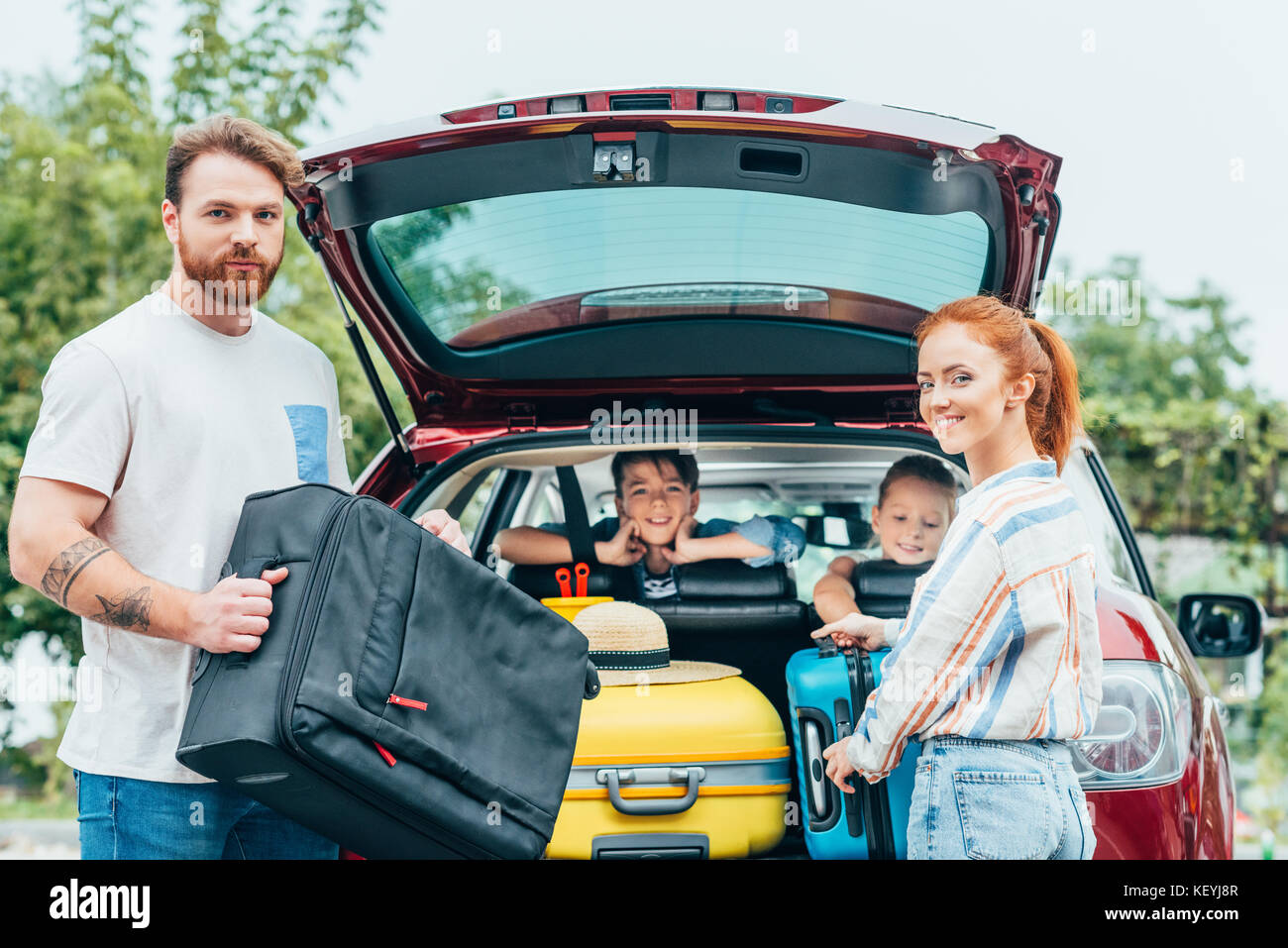 family packing luggage in trunk Stock Photo - Alamy