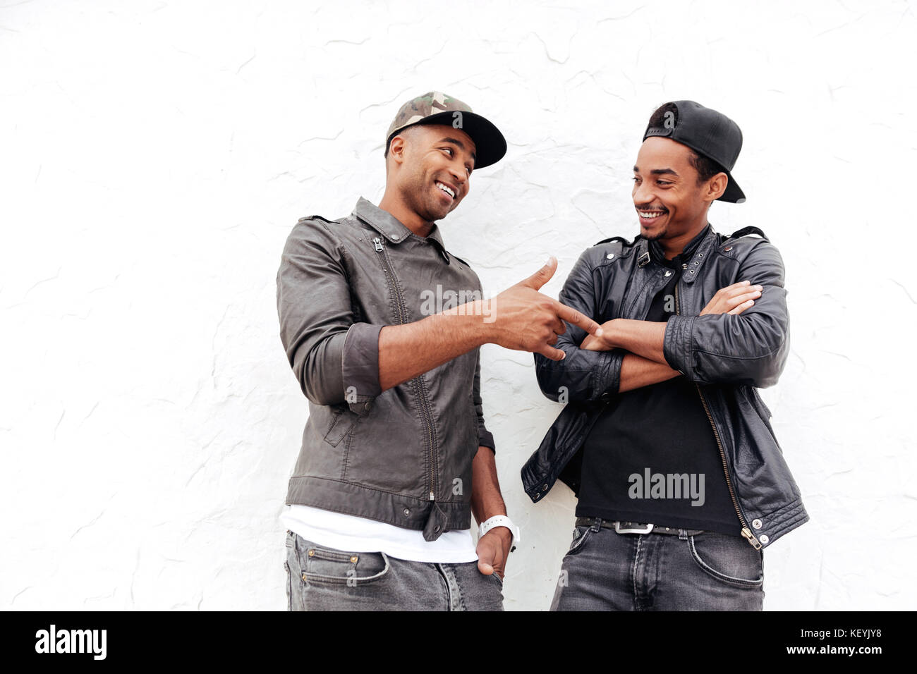 Picture of cheerful two young african men friends standing outdoors ...