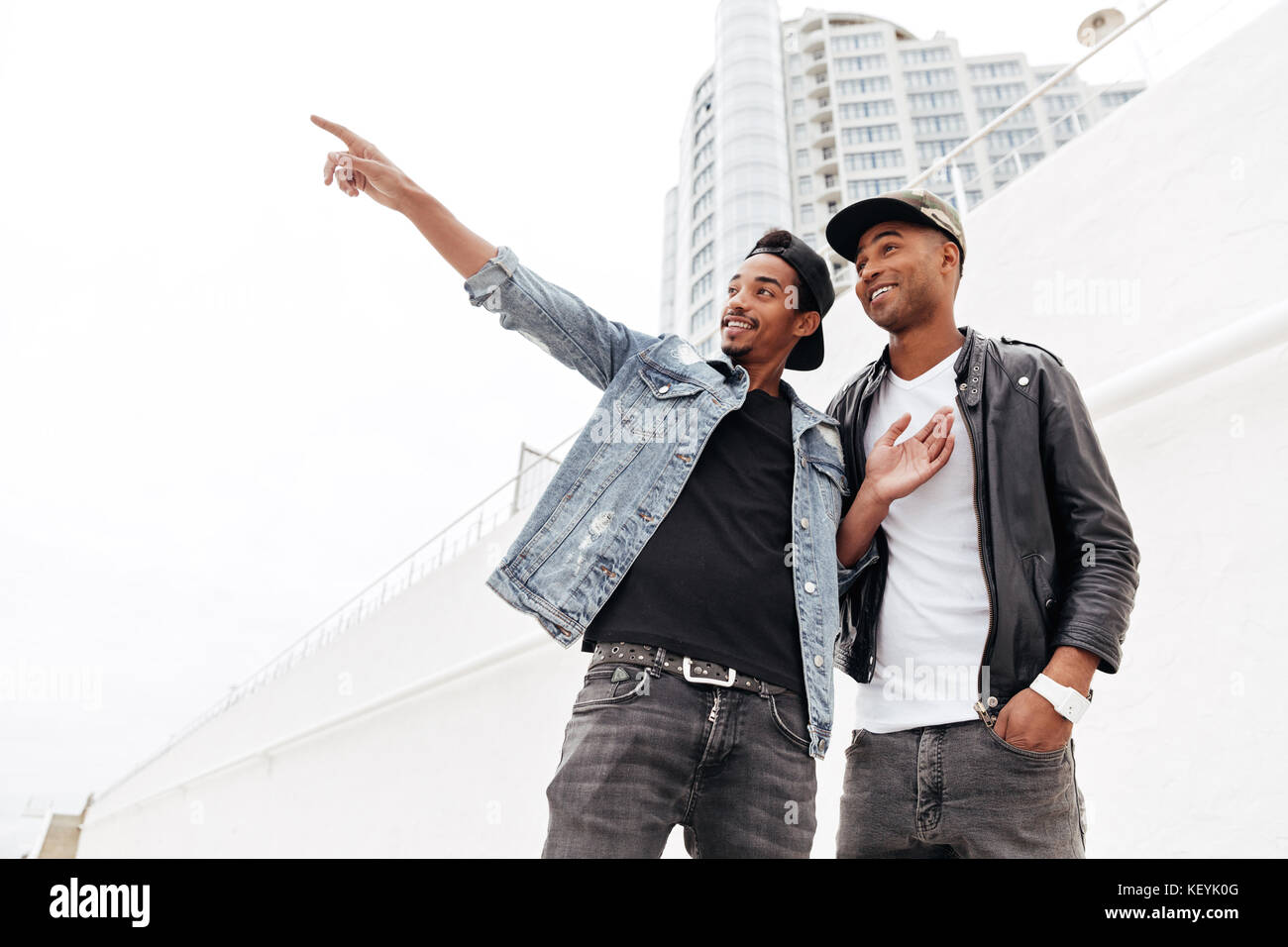Picture of two happy young african men friends walking outdoors ...