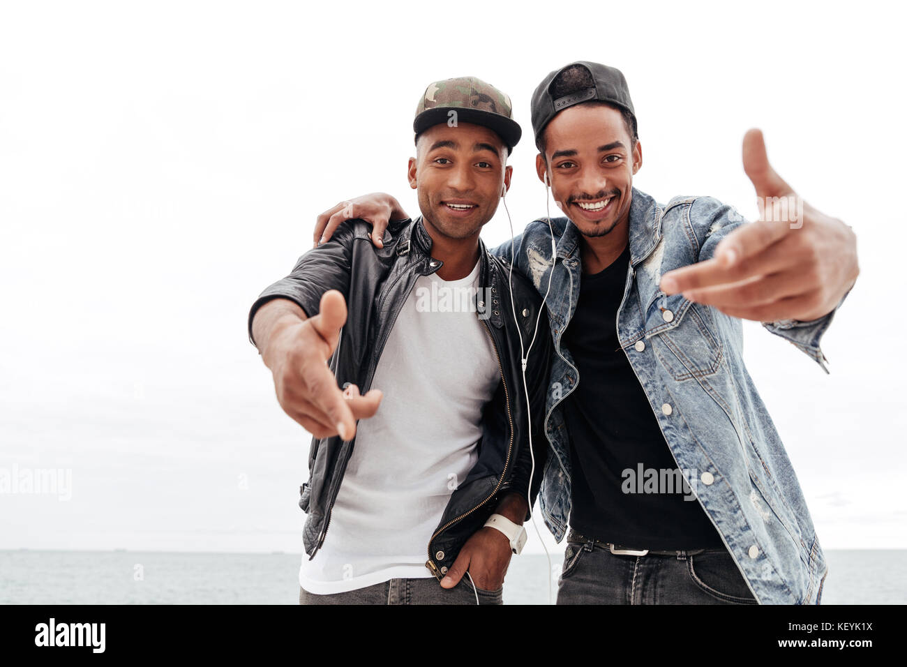Photo of happy two young african men friends walking outdoors. Looking ...