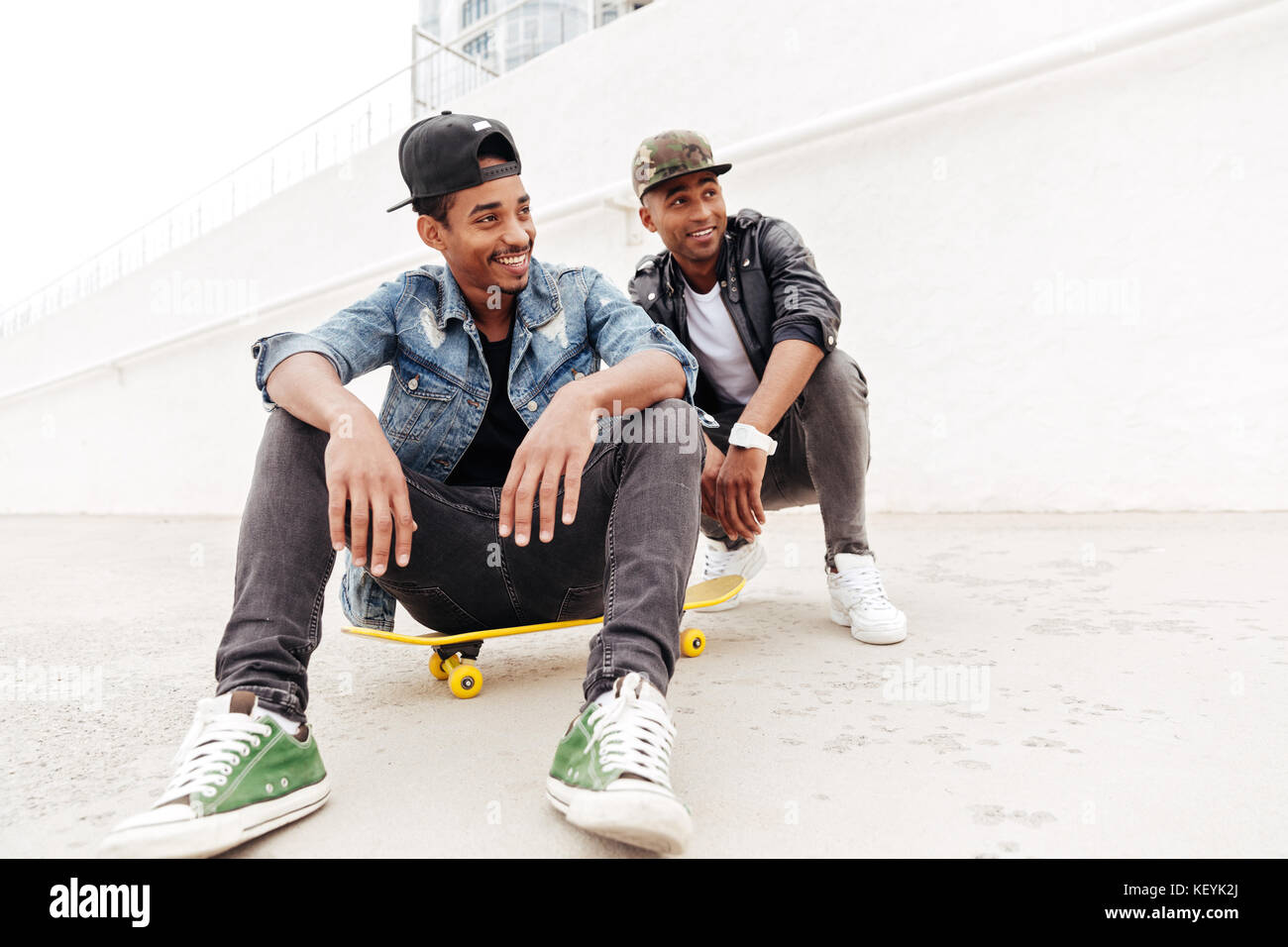 Image of happy two young african men friends walking outdoors sitting ...