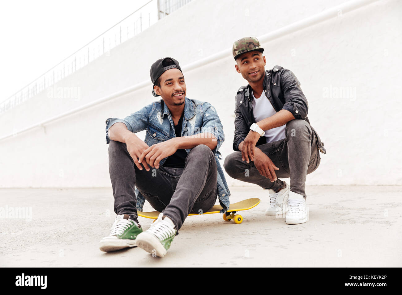 Image of happy two young african men friends walking outdoors sitting ...