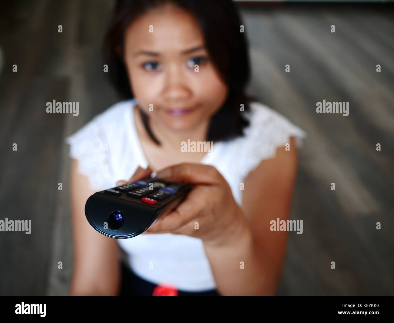Woman holding a TV remote control, change concept Stock Photo - Alamy