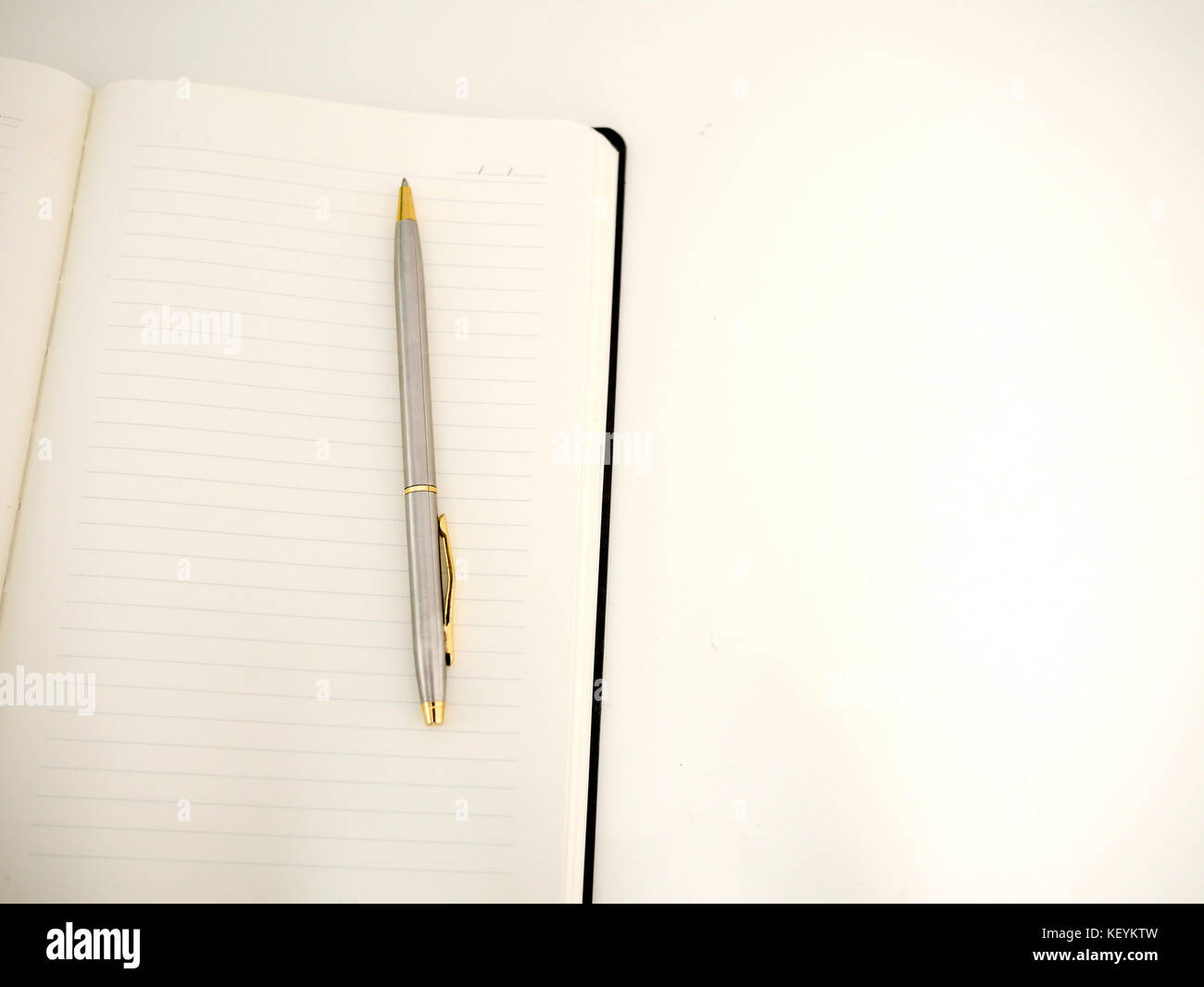 White plain notebook with a pen on white background Stock Photo - Alamy