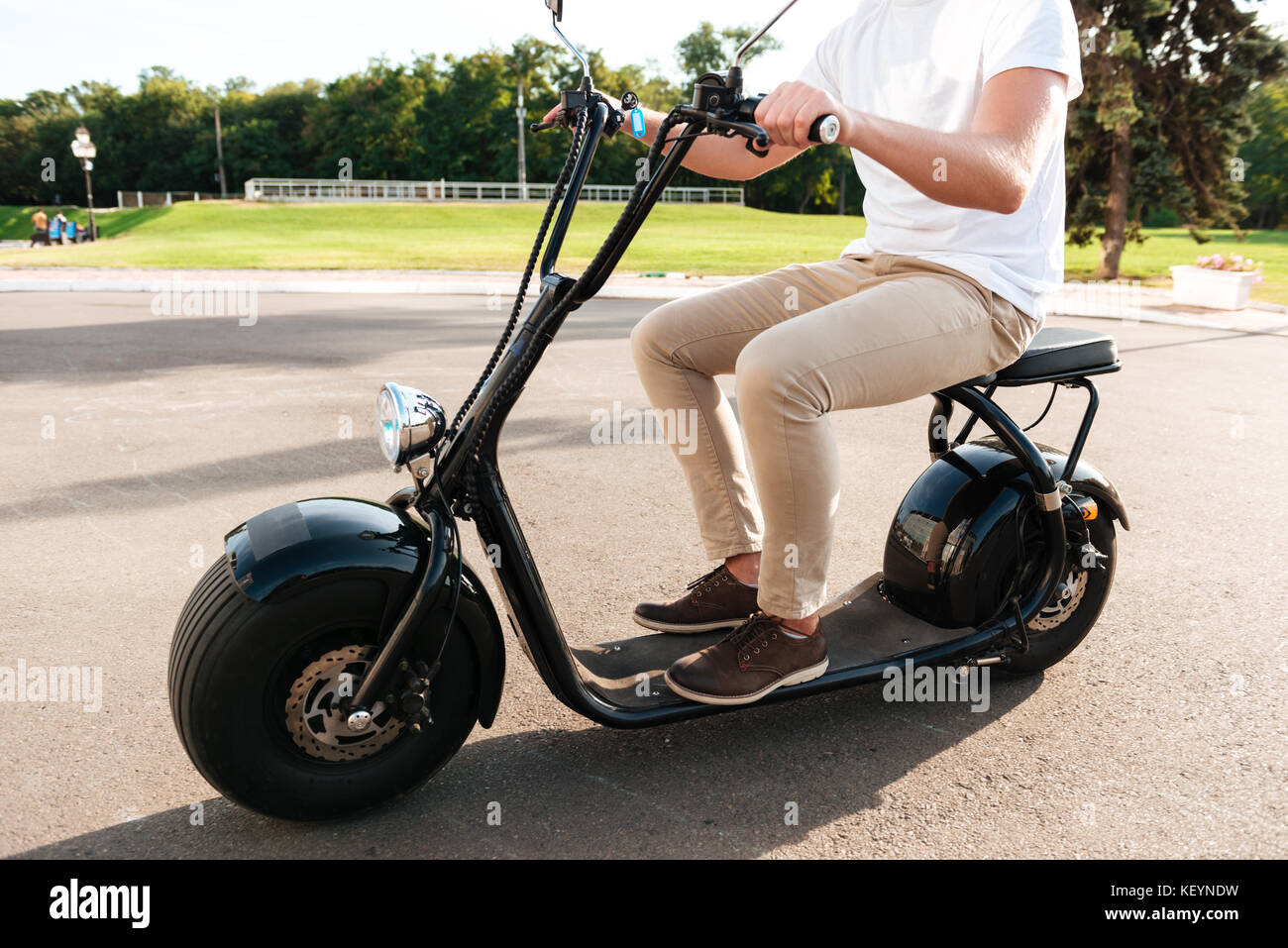 Cropped side view of young man rides on modern motorbike outdoors Stock ...