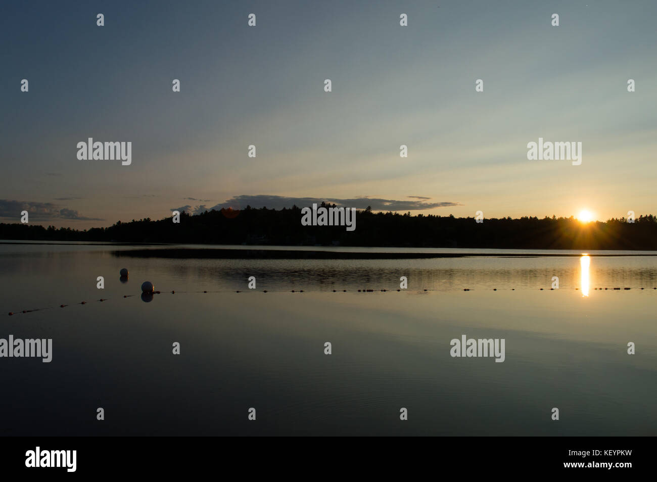 Gorgeous New Hampshire lake reflects the sky on a fall afternoon during ...