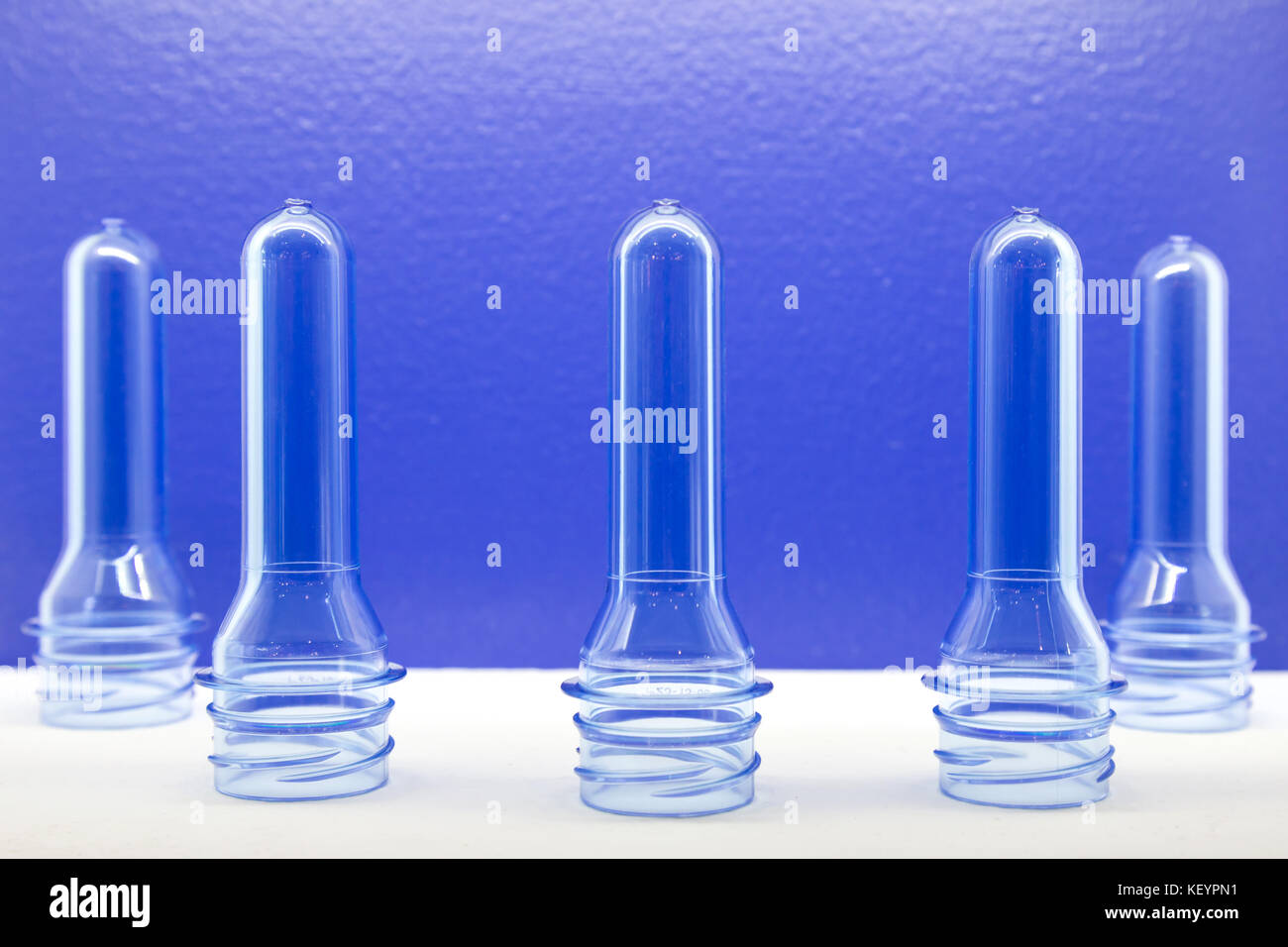 group of transparent plastic PET preforms are displayed on the shelf in ...