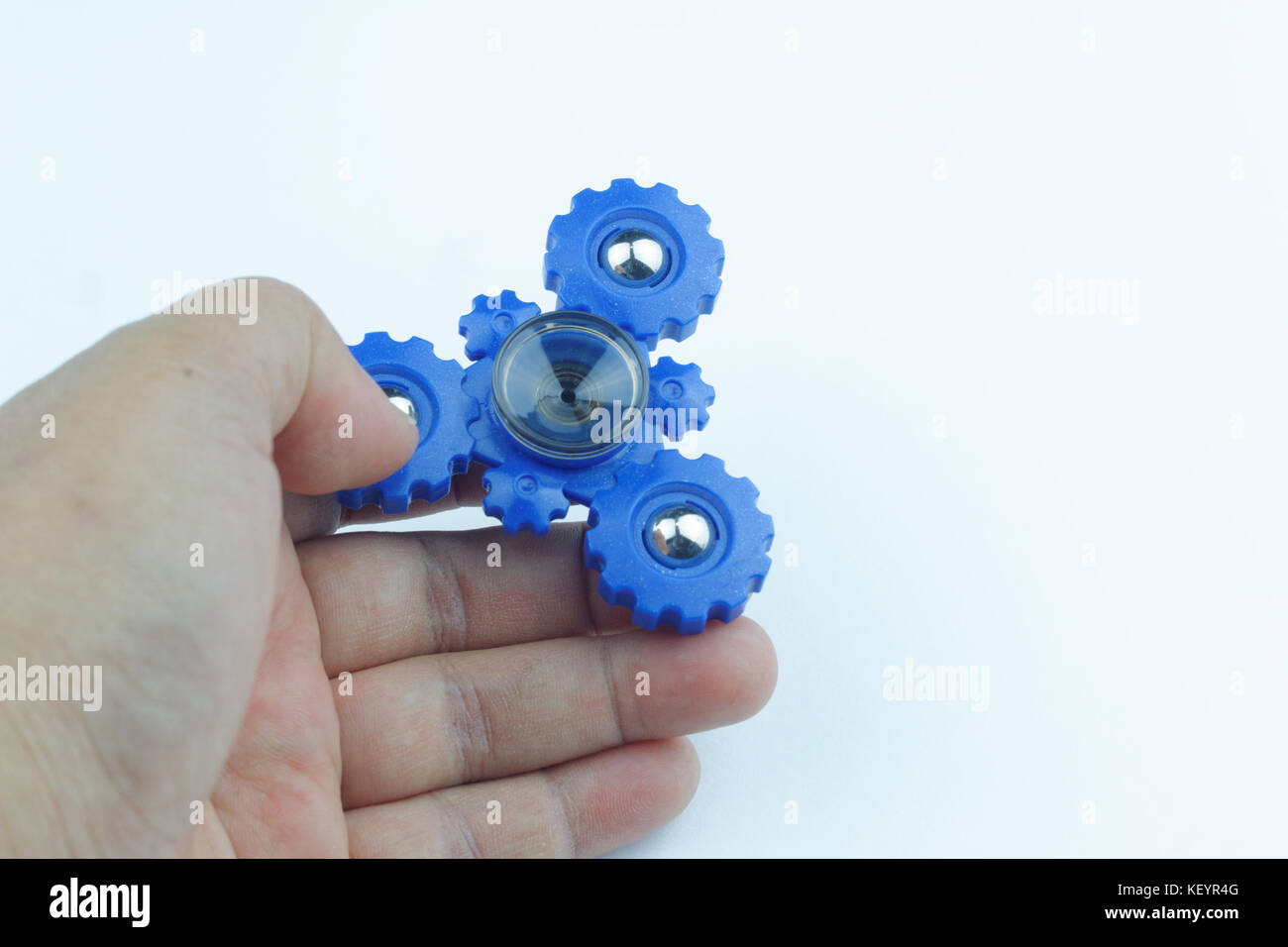 Hand holding blue color fidget finger spinner stress, anxiety relief ...