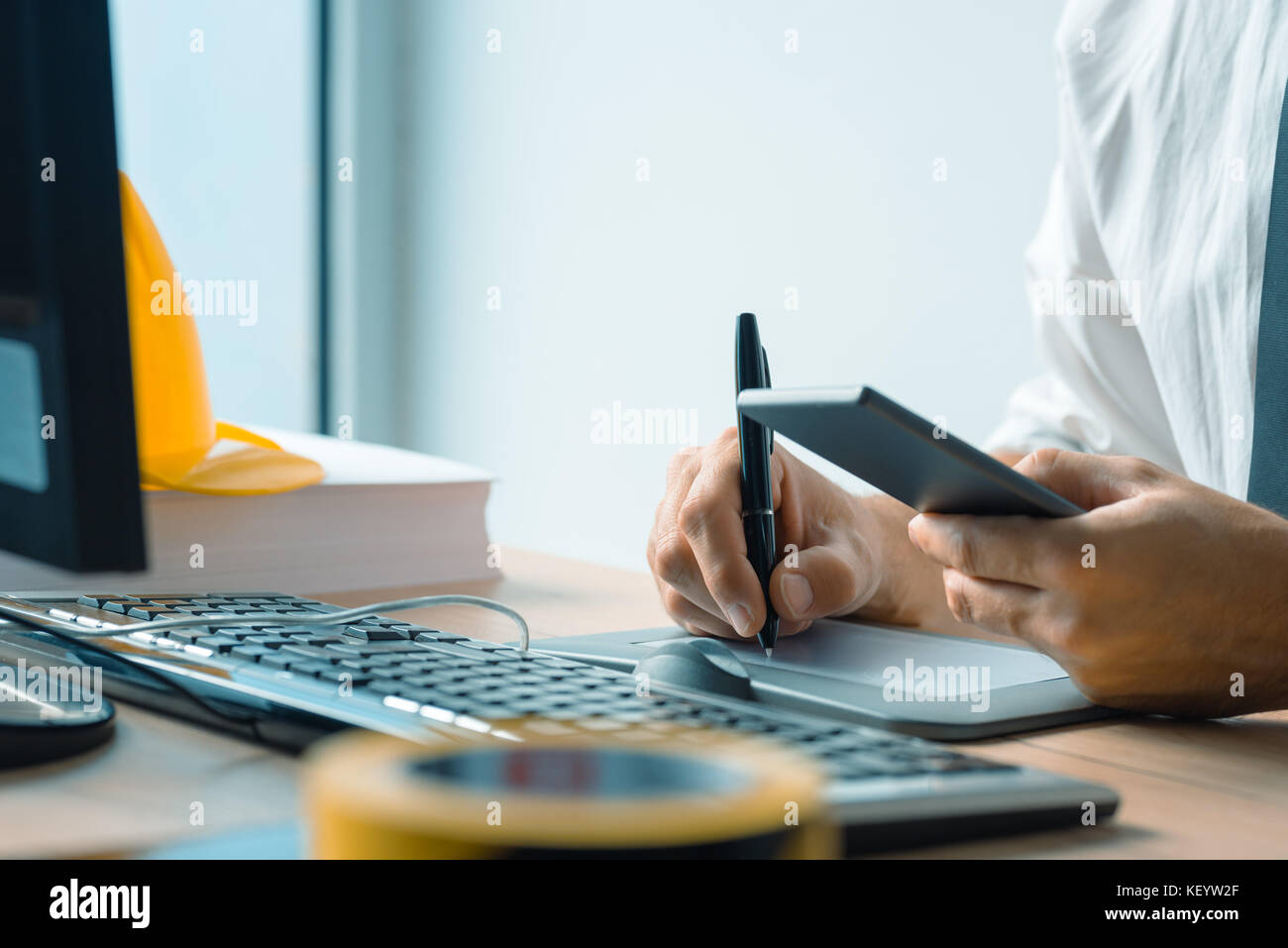 Architect working with sketch pen tablet and CAD software in ...