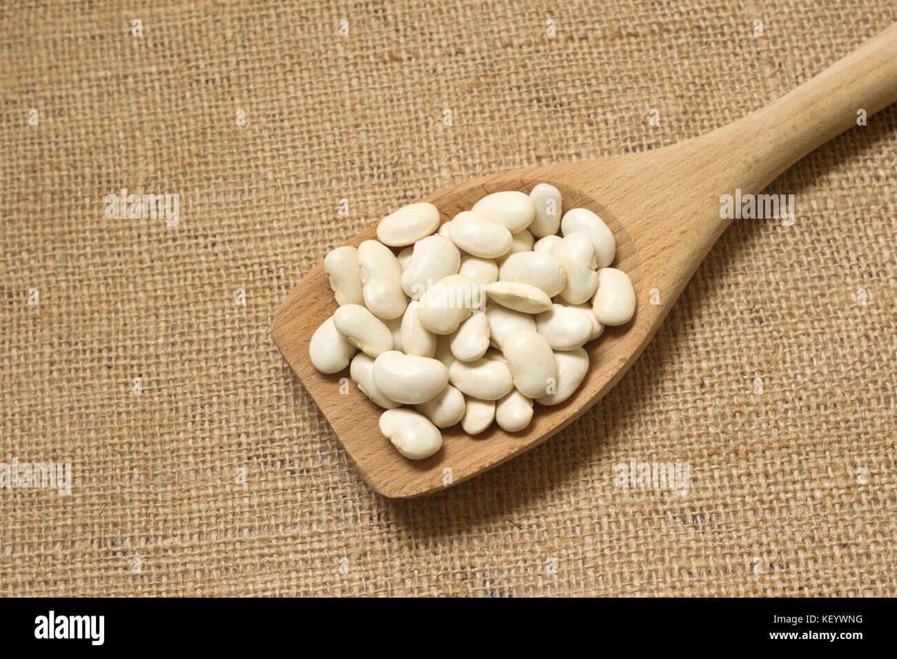 Wooden spoon with white beans Stock Photo - Alamy