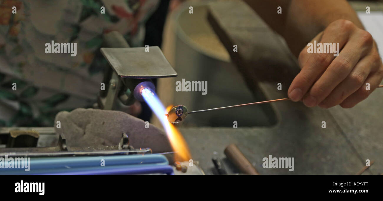 Glass-maker while melting and shaping the glass with a very high ...