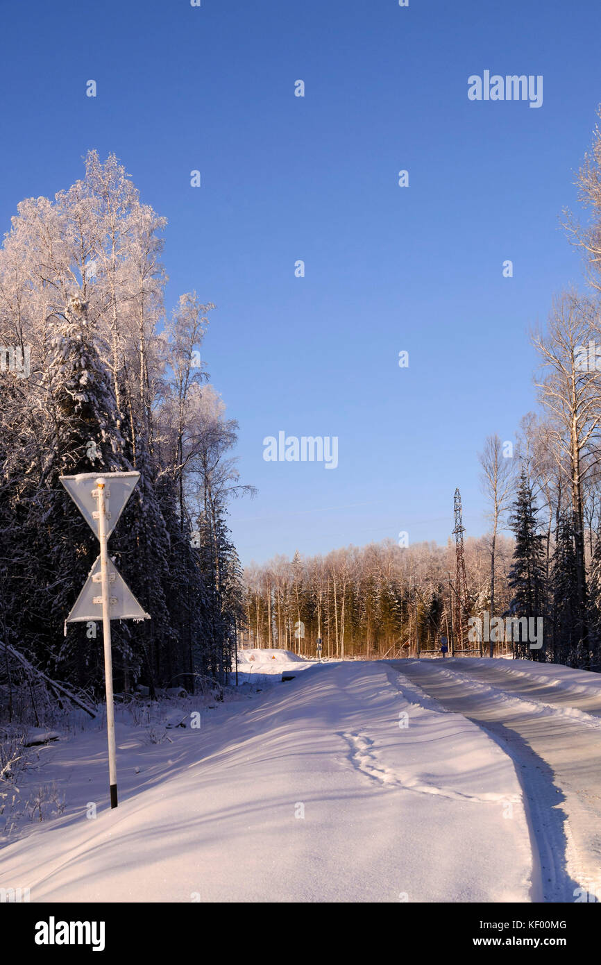 road sign with snow on road in winter forest day Stock Photo - Alamy