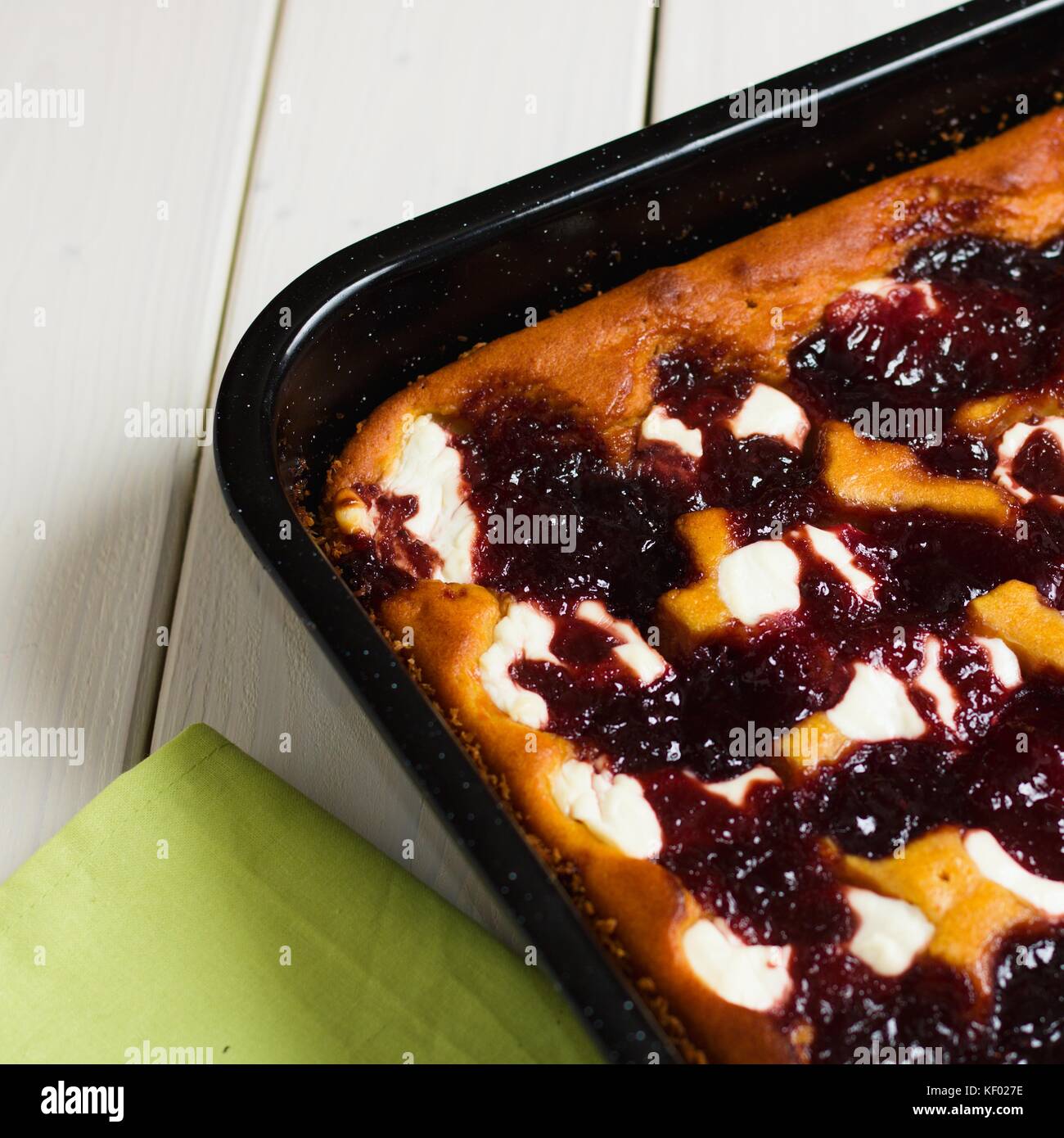 Corner of home baked cake with cottage cheese and fruit jam in black ...
