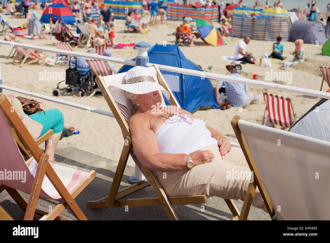 Lady sunbathing in a deck chair on the beach Stock Photo - Alamy