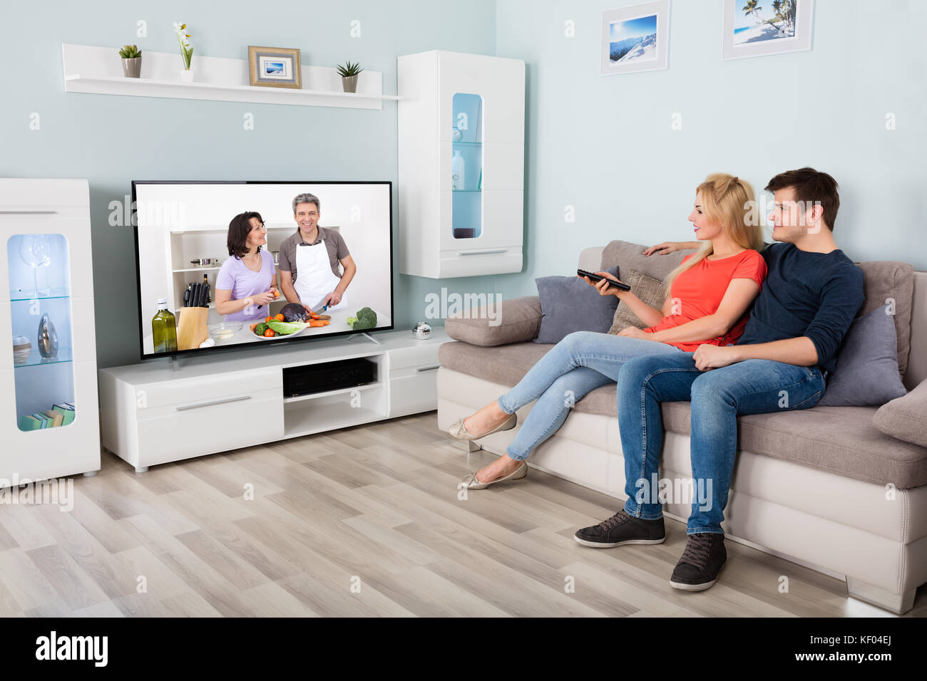 Young Couple Watching Cooking Show On Television At Home Stock Photo ...