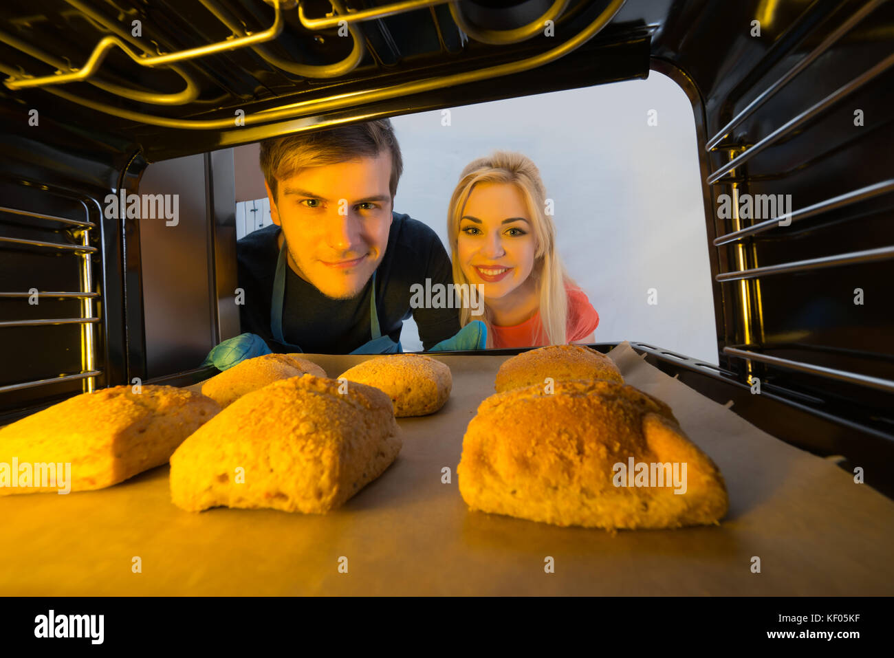 Close-up Of Young Couple Baking Bread In The Oven Stock Photo - Alamy