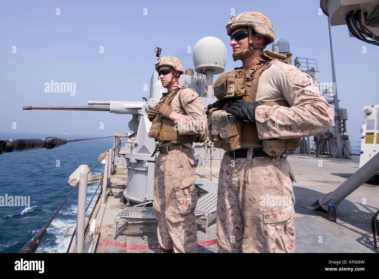 U.S. Marines stand watch on the gun mount aboard the U.S. Navy Harpers ...