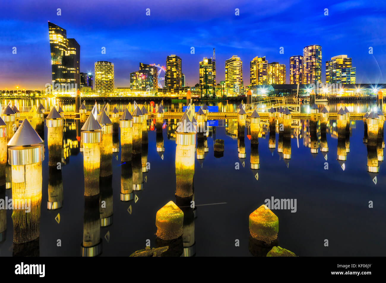 Matrix of timber jetty poles pinning out of still waters of Yarra river ...
