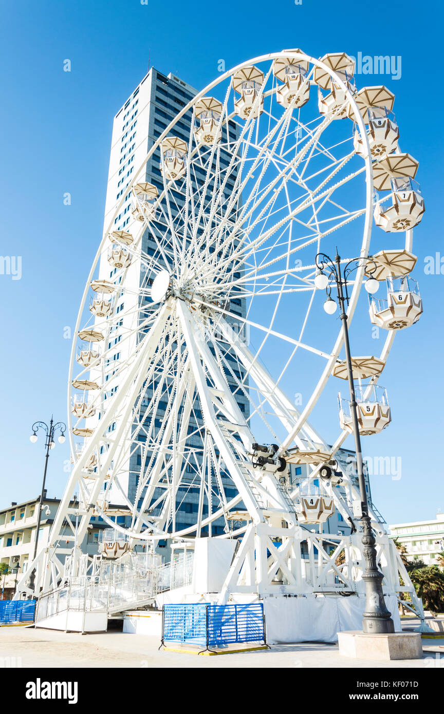 Panoramic ferris wheel with skyscraper on background Stock Photo - Alamy