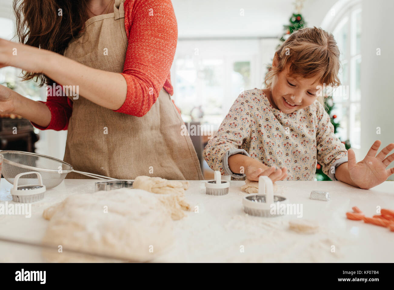 Little girl having fun making cookies. Woman with her daughter making ...