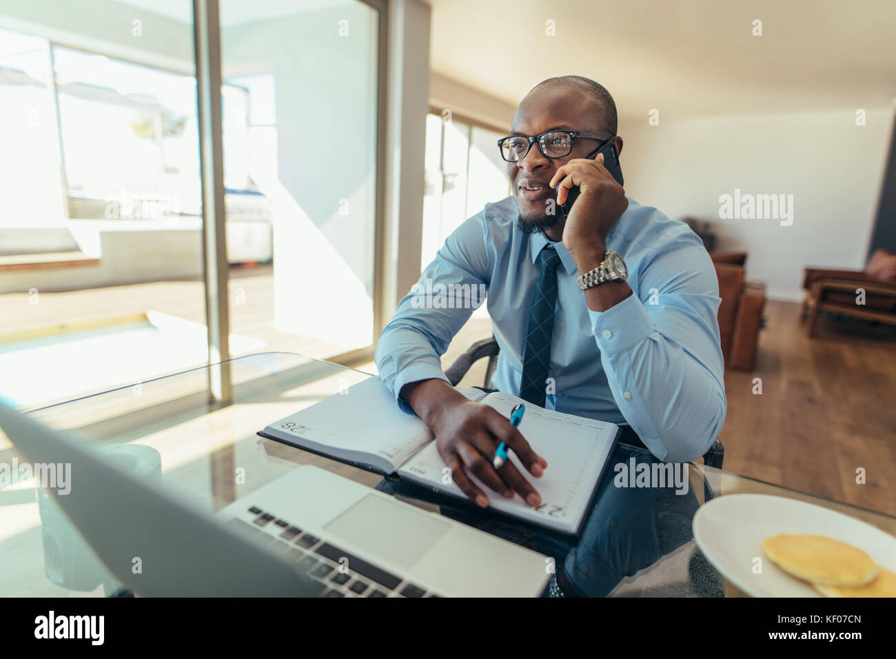 businessman talking over phone while sitting in front of laptop ...