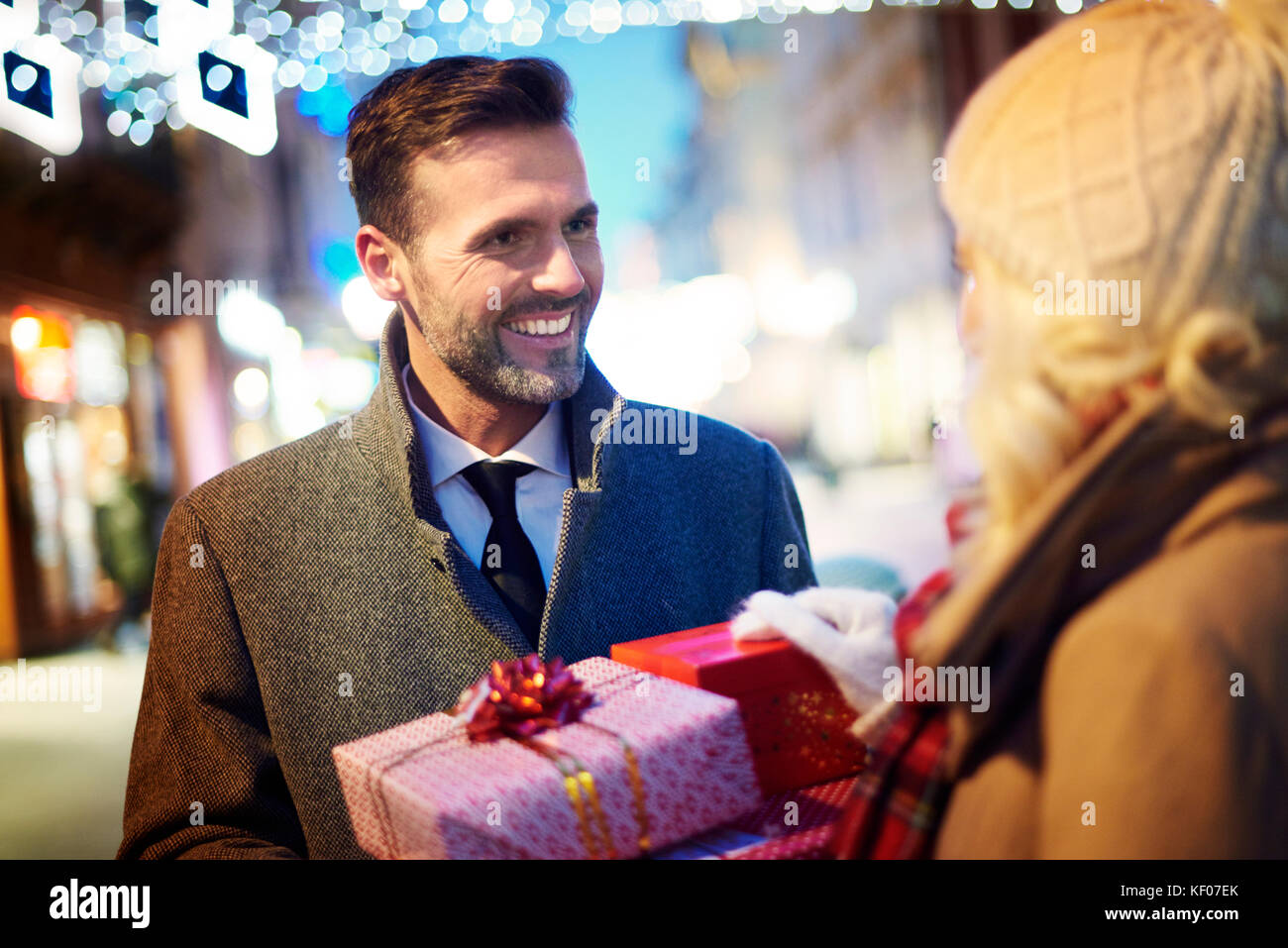Man surprising woman with unexpected gifts Stock Photo - Alamy