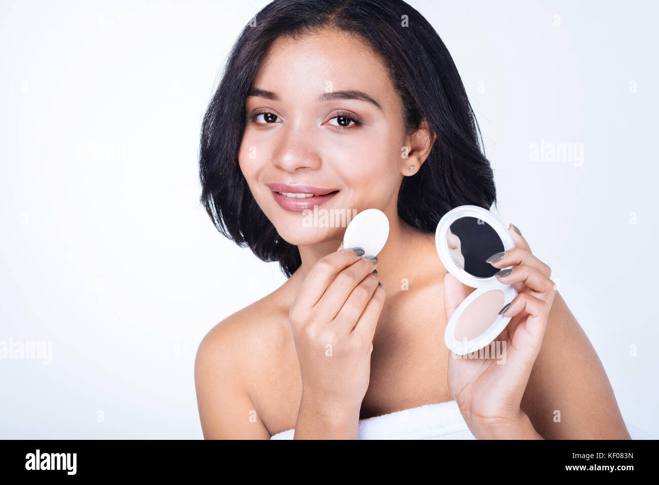 Pretty young woman holding face powder and puff Stock Photo - Alamy