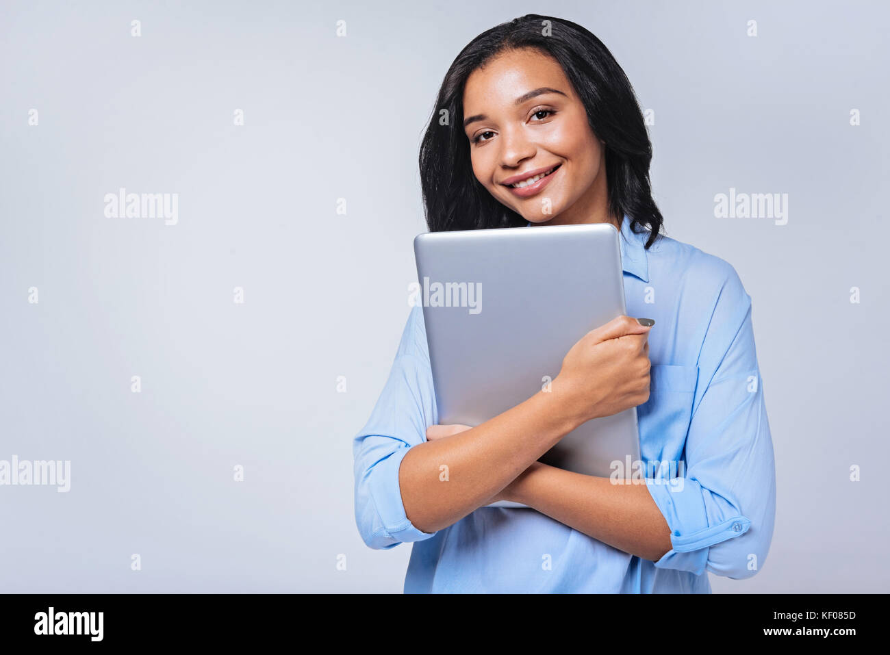 Smiling woman pressing laptop to her chest Stock Photo - Alamy