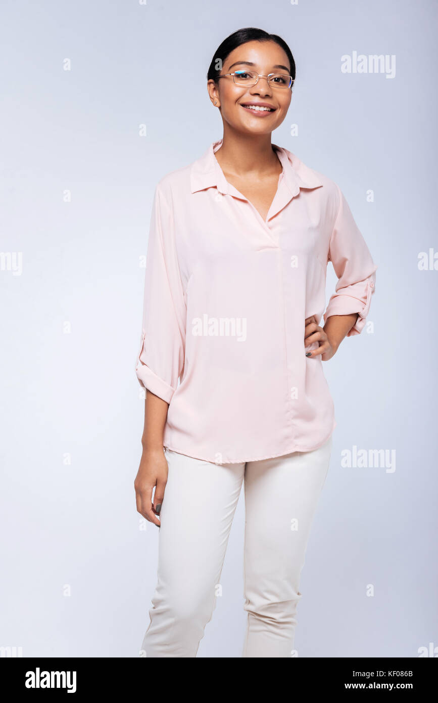 Pleasant woman in pink blouse posing against blue background Stock ...