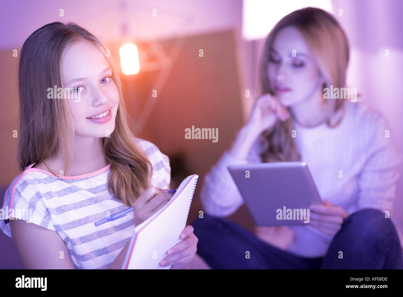 Smiling girl writing in her notebook Stock Photo - Alamy