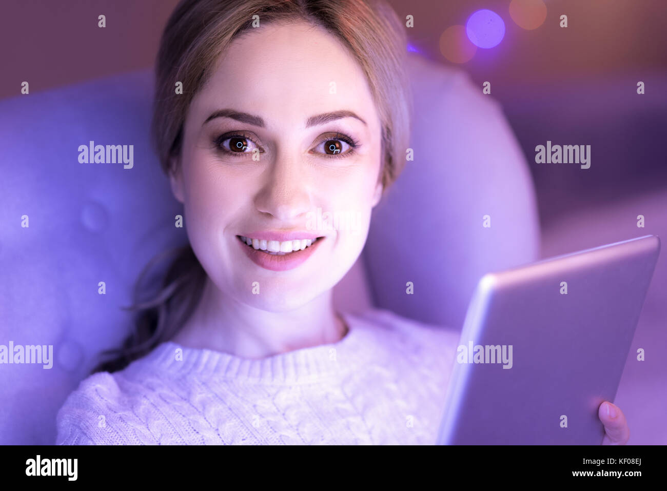 Inspired woman beaming with happiness while using her tablet Stock ...
