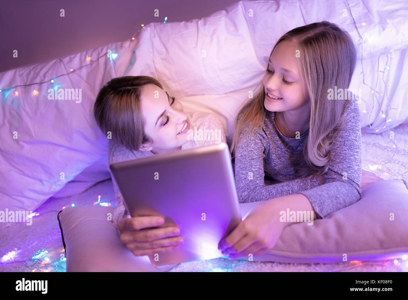 Delighted mother and daughter relaxing and smiling Stock Photo - Alamy