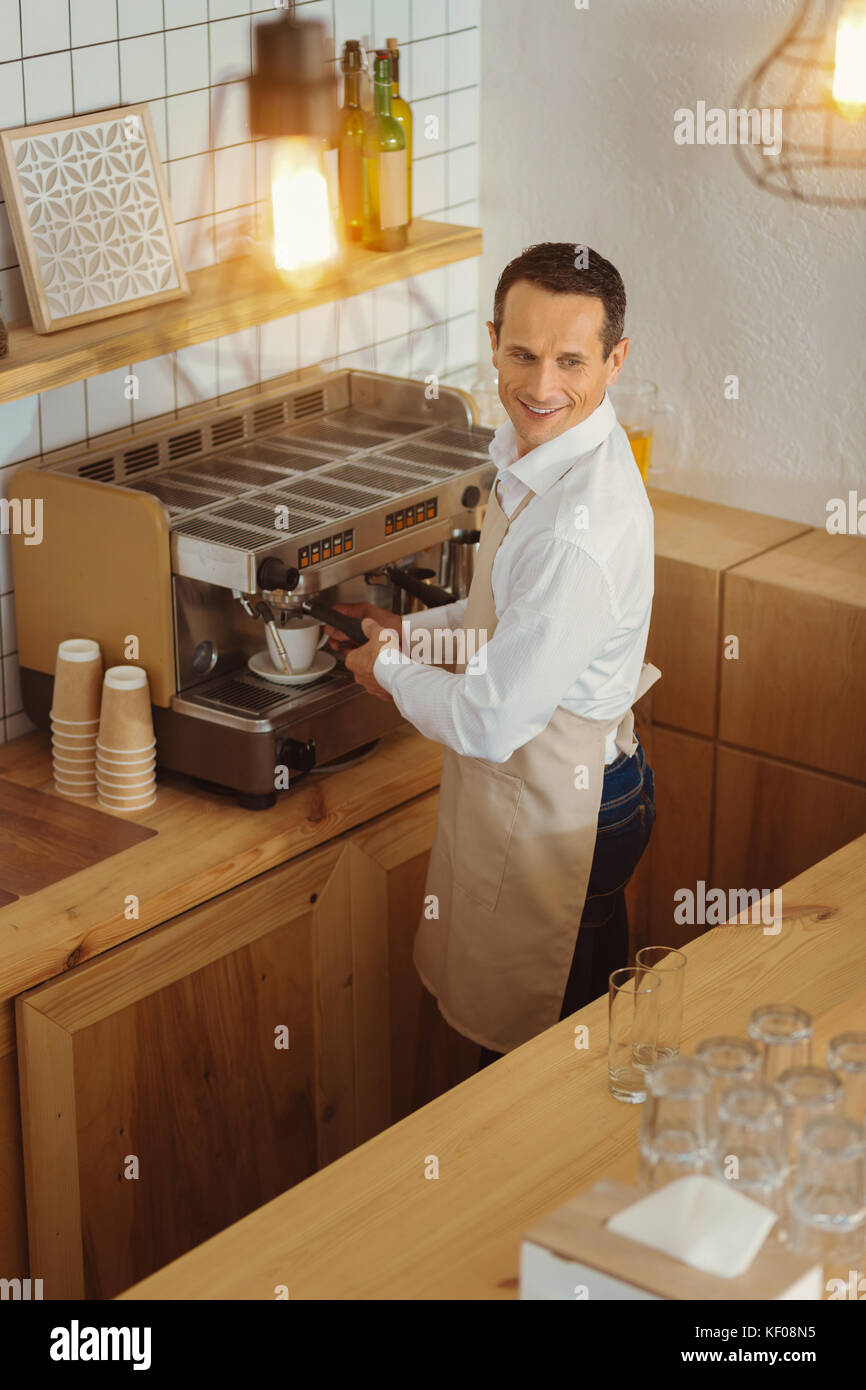 Delighted positive man making coffee Stock Photo - Alamy