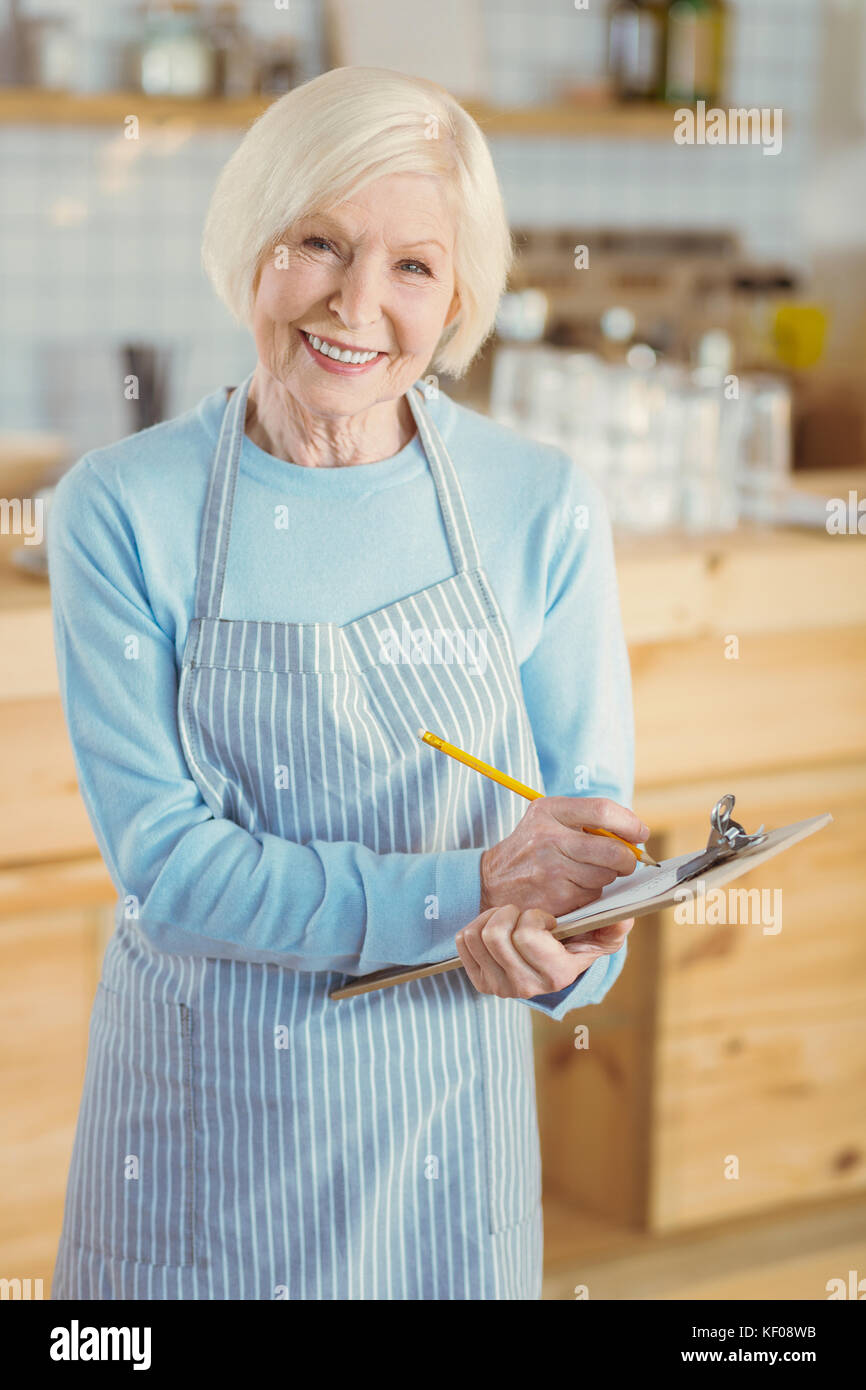 Positive elderly woman wearing an apron Stock Photo - Alamy