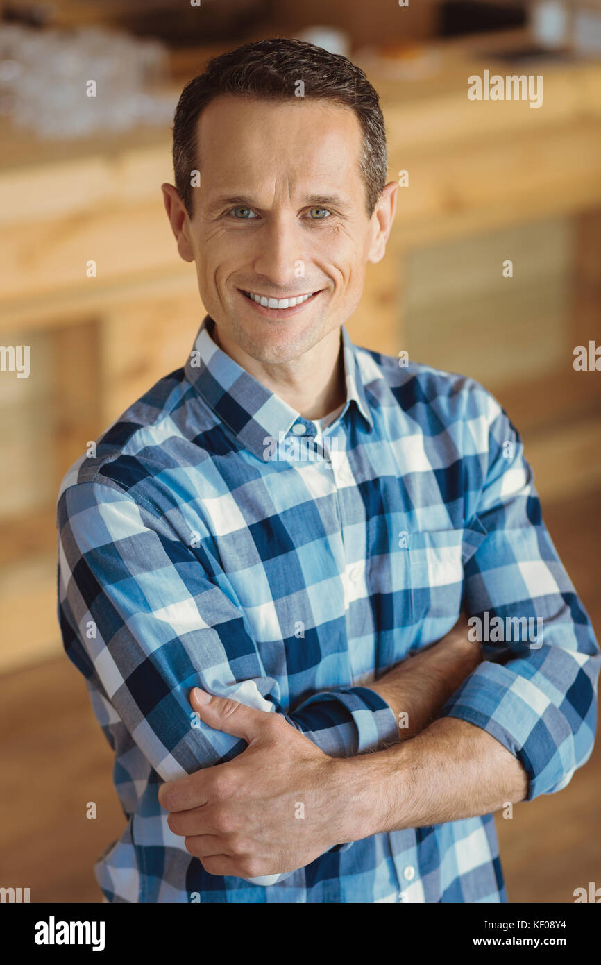 Pleasant cheerful man standing cross handed Stock Photo - Alamy